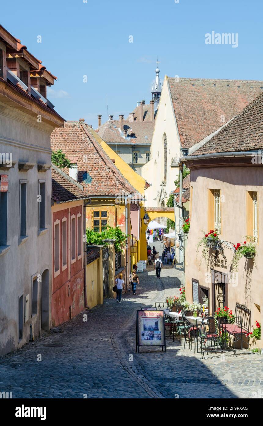 Stone paved old streets with colorful houses in Sighisoara fortress ...
