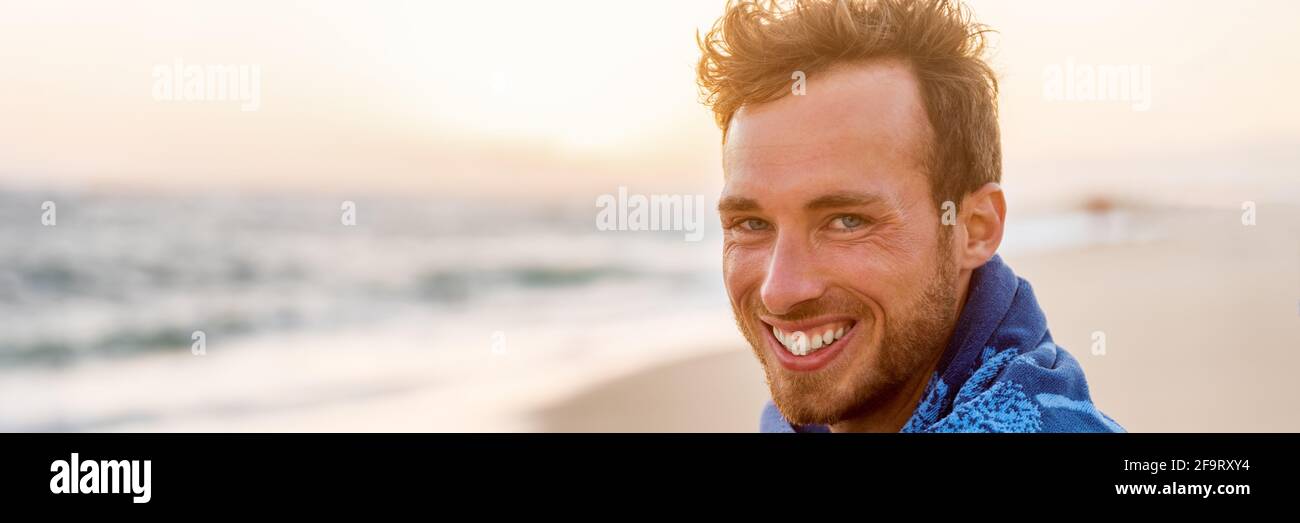 Smiling handsome young man beauty portrait on beach at sunset looking ...
