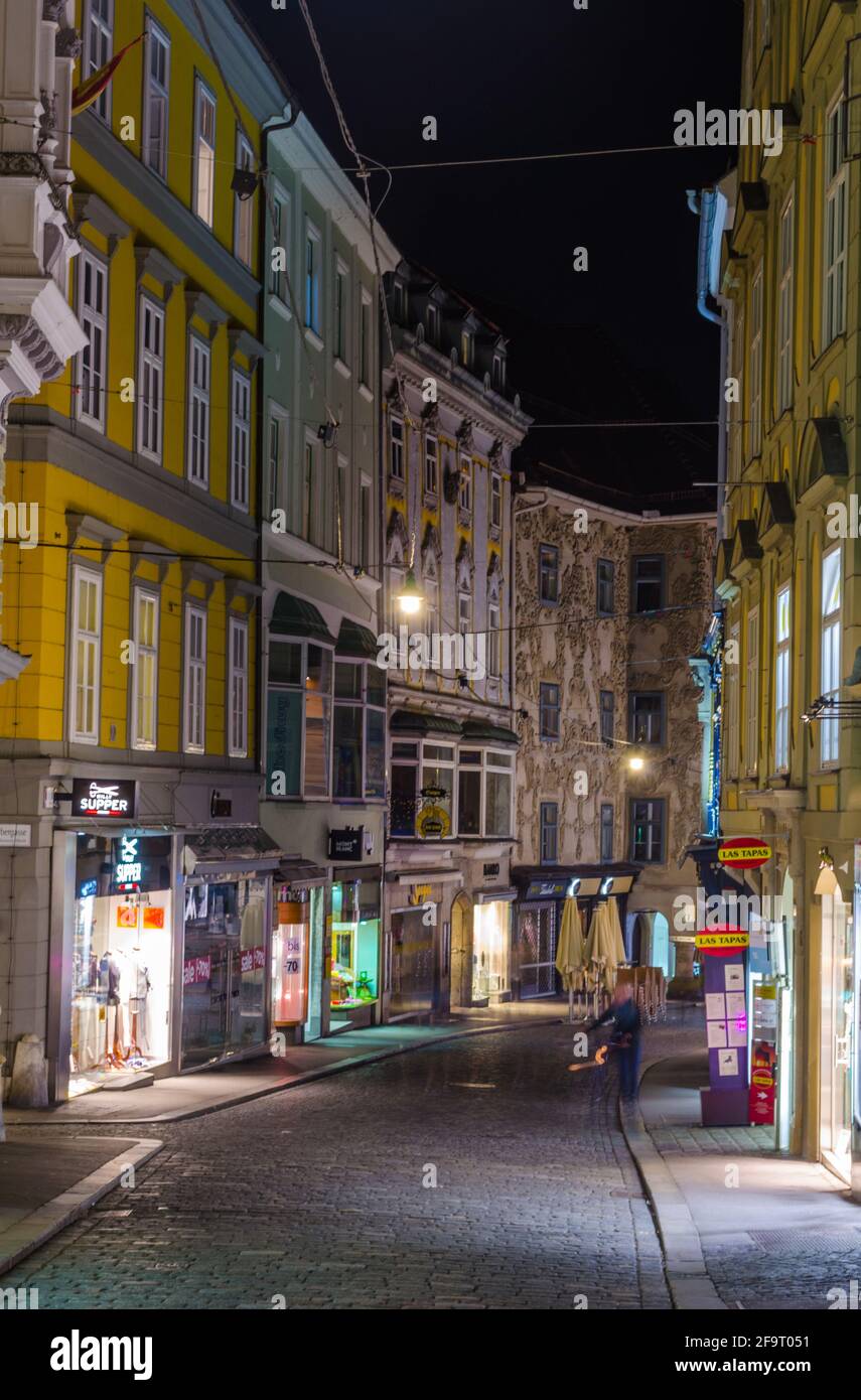 night view of an illuminated street in the historical center of Graz in ...