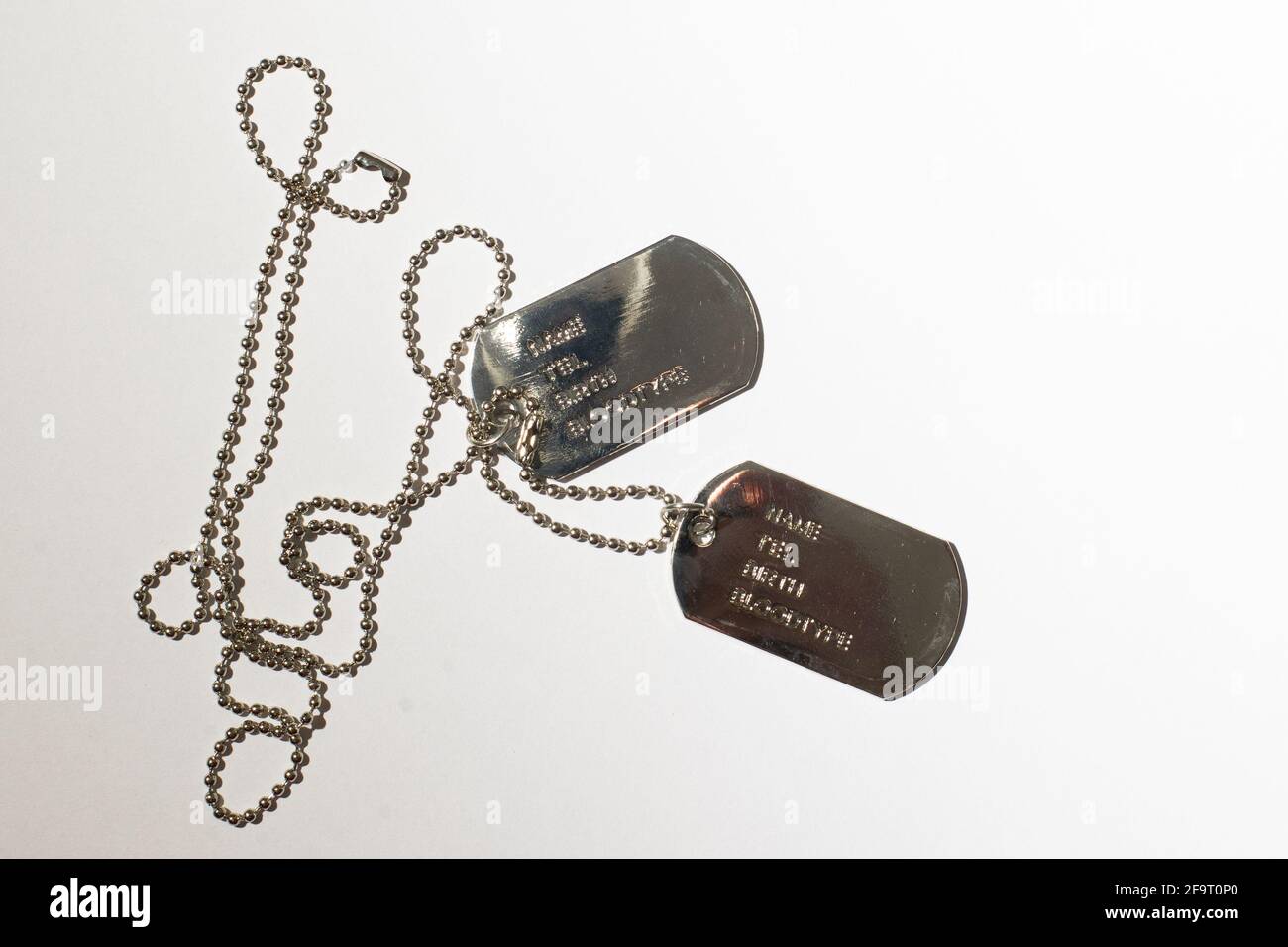 Identification badges on a chain, army badge Stock Photo - Alamy