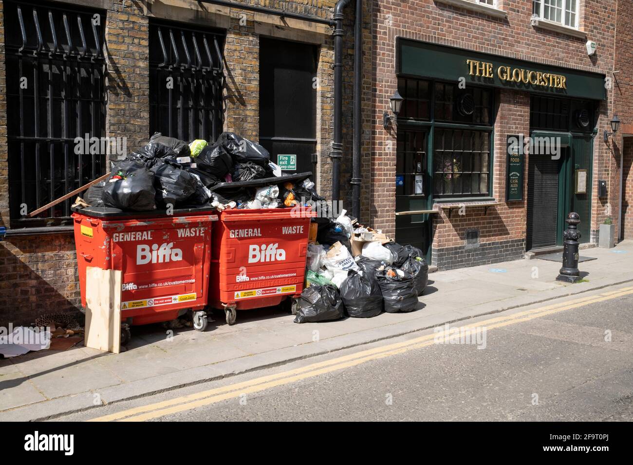 Piles of rubbish and recycling in and around bins outside a pub in ...