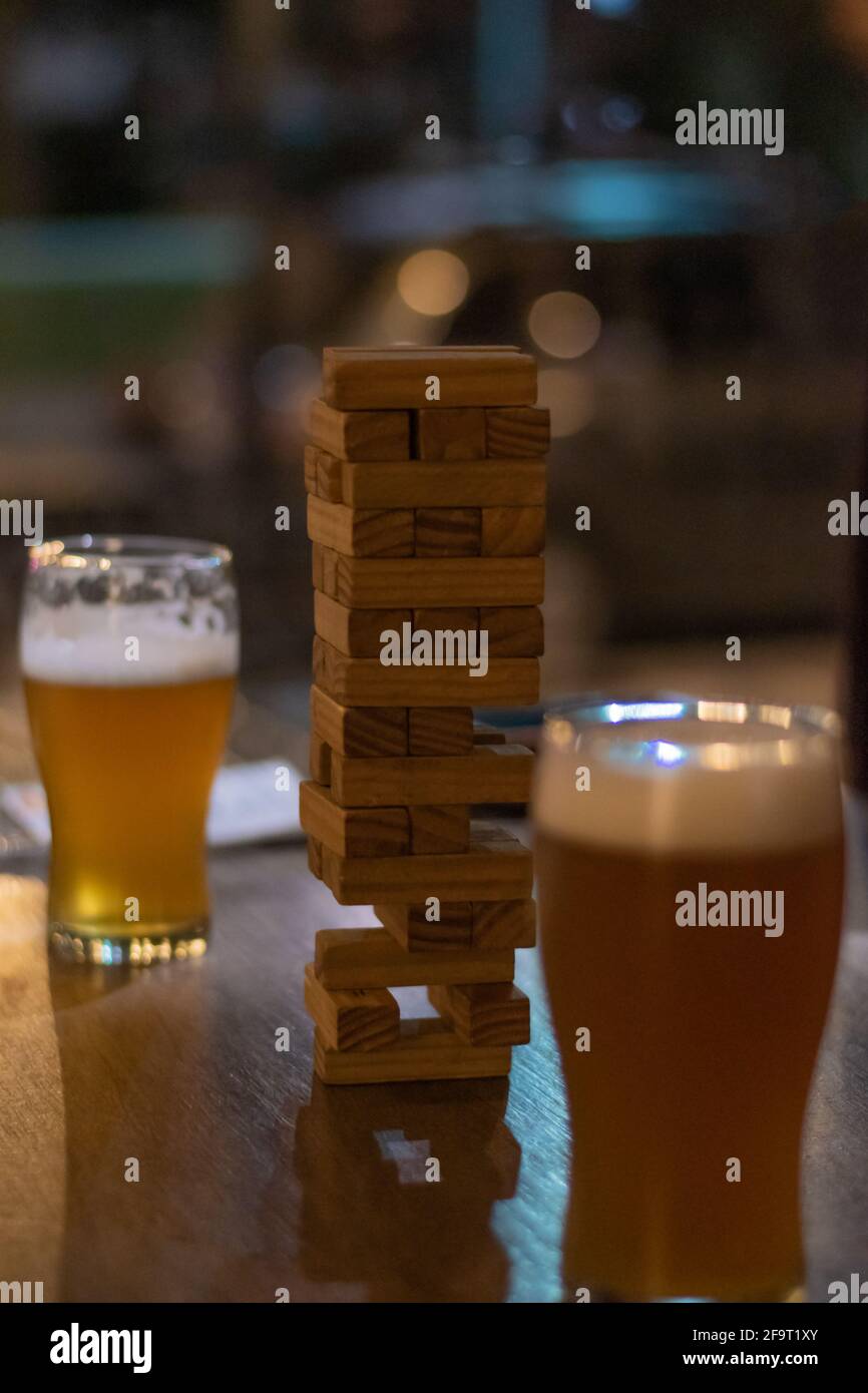 Vertical shot of glasses of beer with wooden blocks on the table Stock ...
