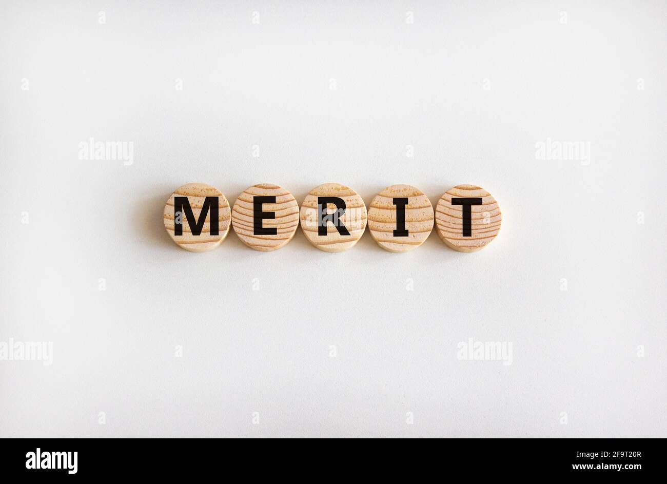 Merit symbol. Wooden circles with the word 'merit'. Beautiful white ...