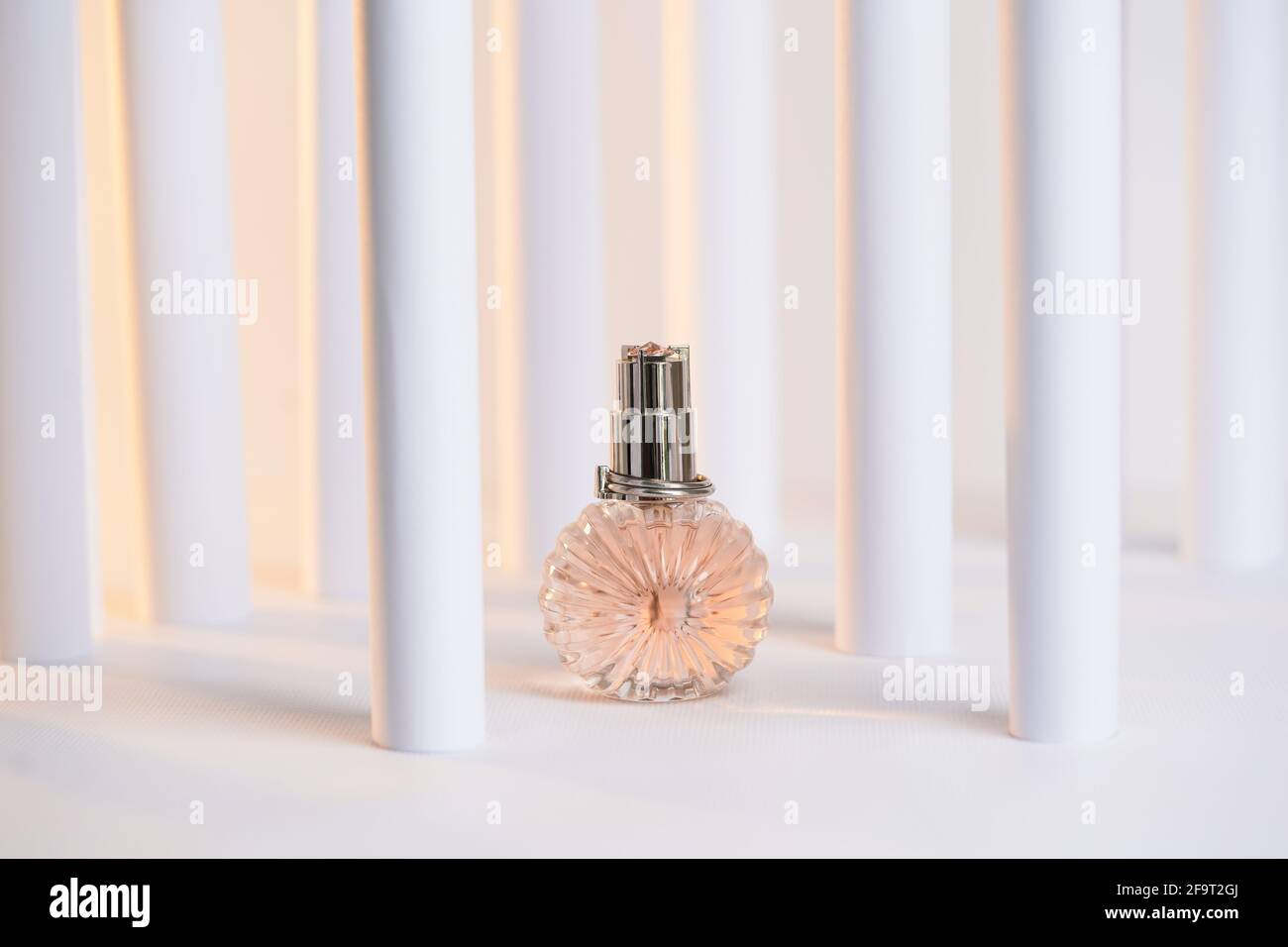 Perfume bottle on white background with columns Stock Photo - Alamy