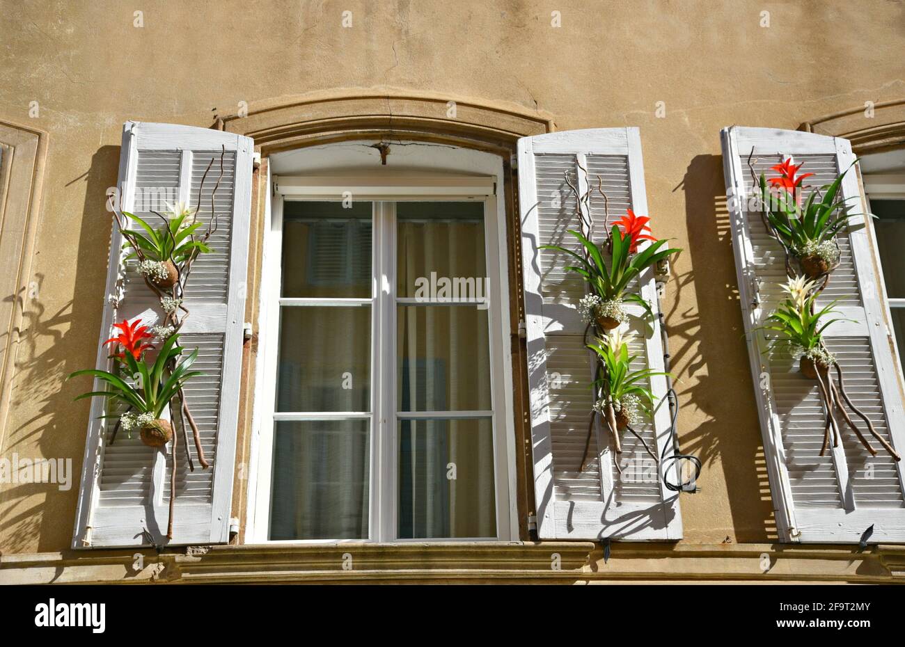 Typical Provençal style facade with an ochre stucco wall and soft white ...