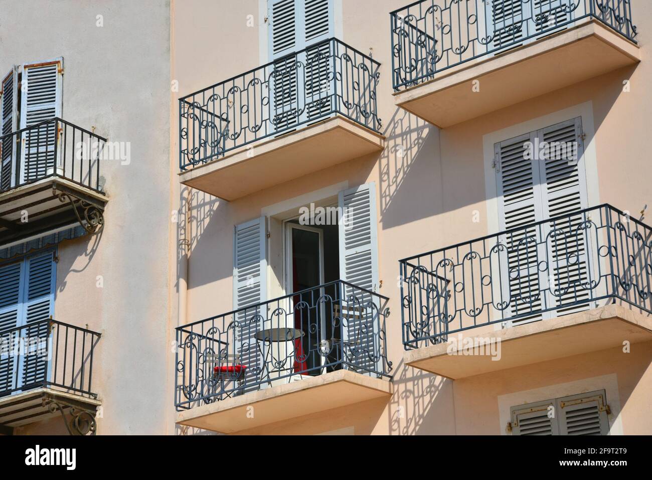 Typical Provençal style facade with a stucco wall, wooden shutters and ...