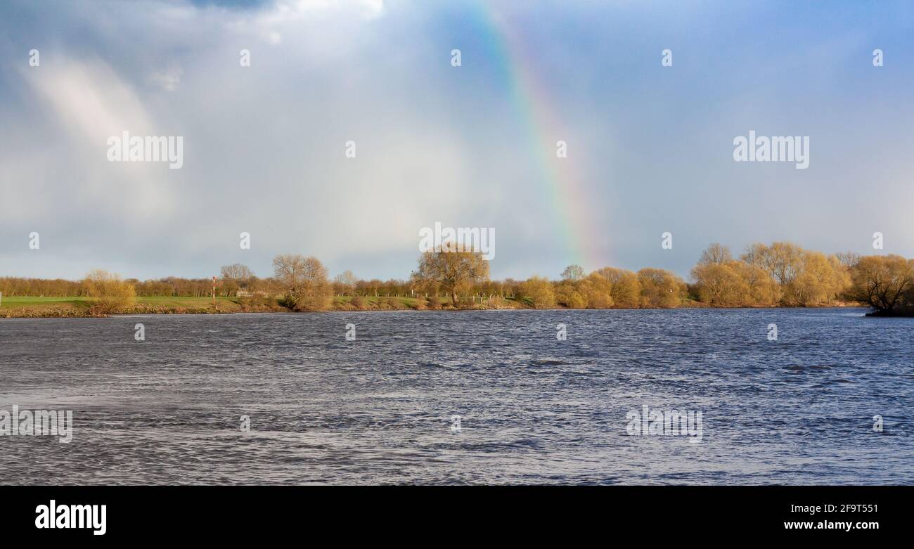 View on a river with a rain blow green vegetation and rain clouds Stock ...