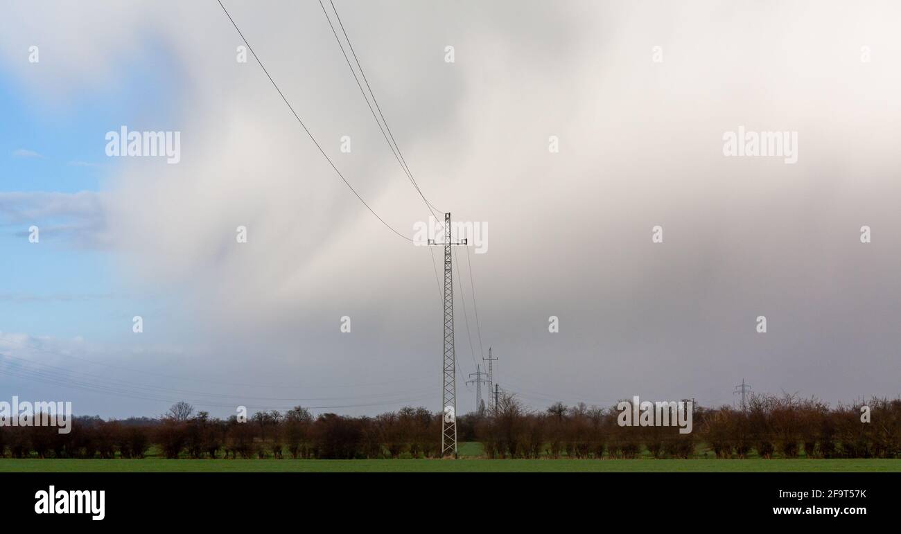 Power line crossing the countryside with storm clouds after heavy ...