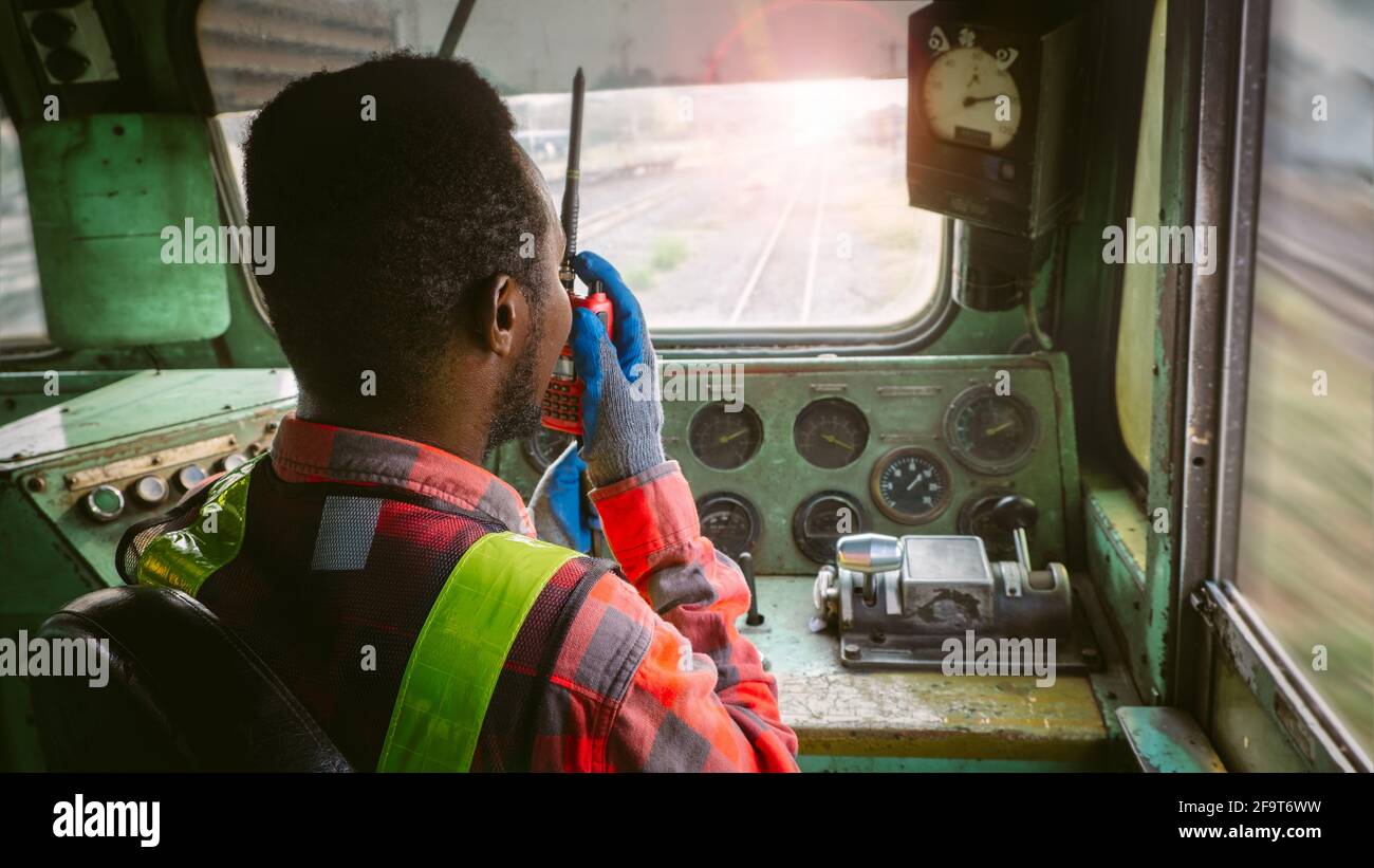 African train driver talking radio communication or walkie talkie in ...