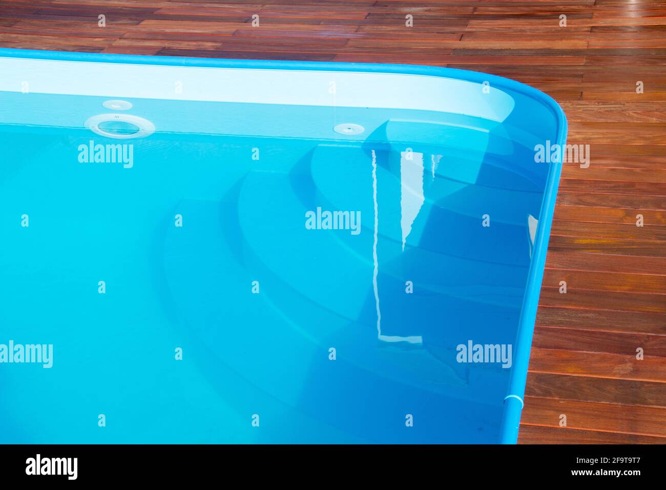 Ipe wood deck around swimming pool edge. poolside decking design, blue ...