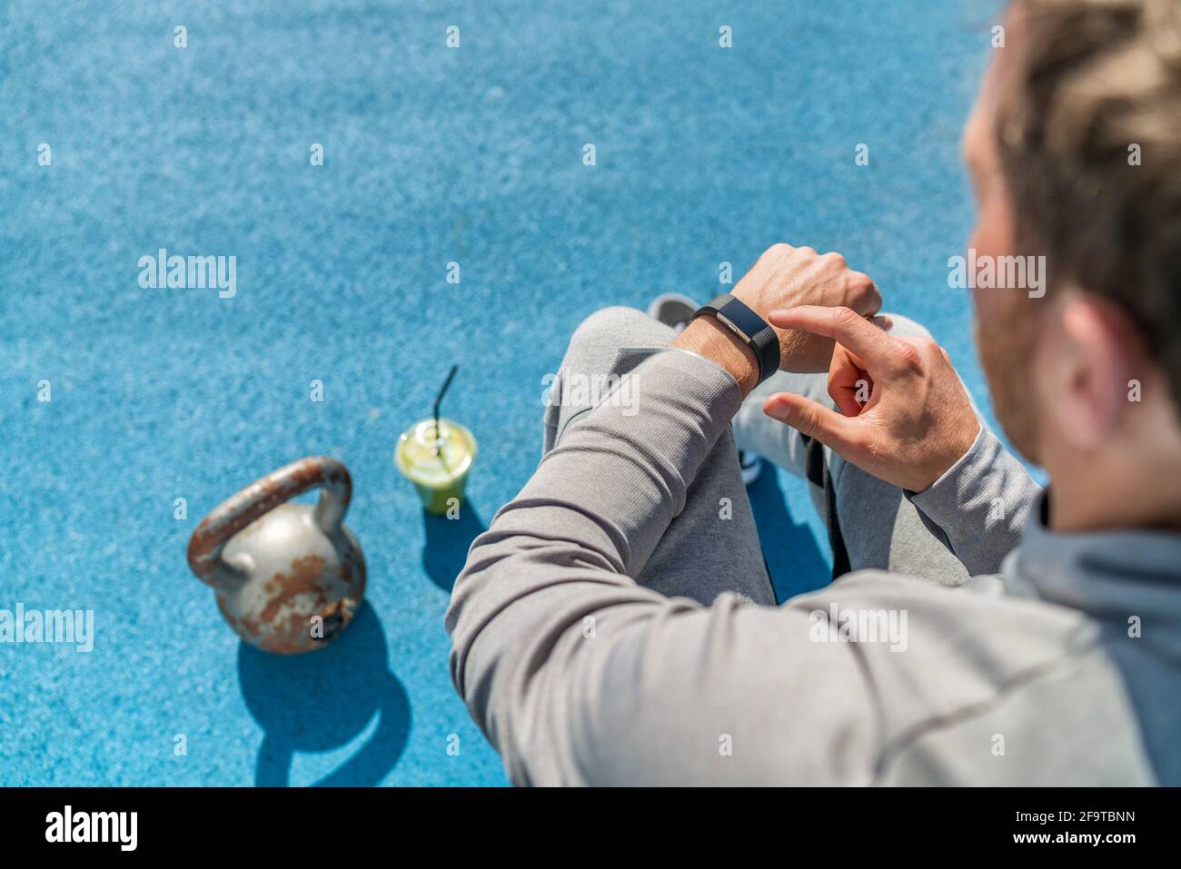 Gym fitness strength training man using sport watch smartwatch ...