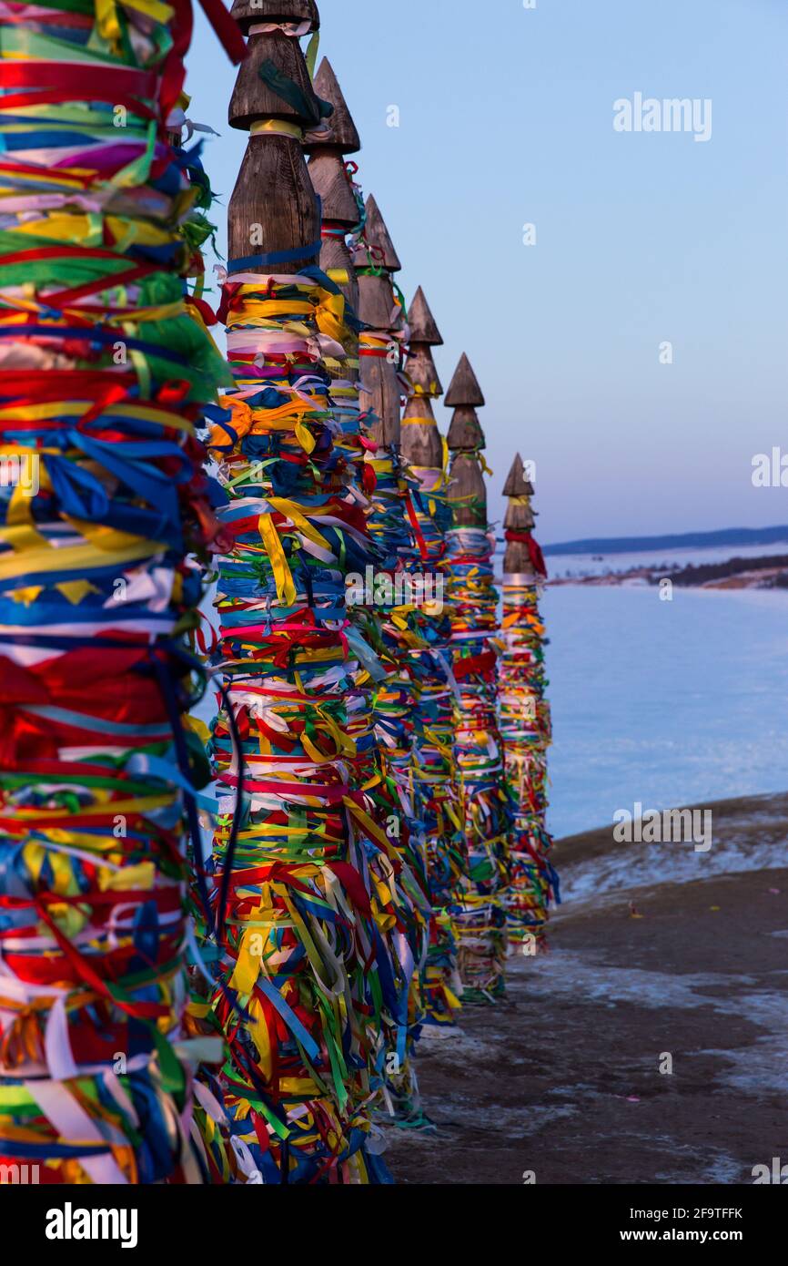 Colored ritual ribbons tied on the tree and wooden poles as a buddhist ...