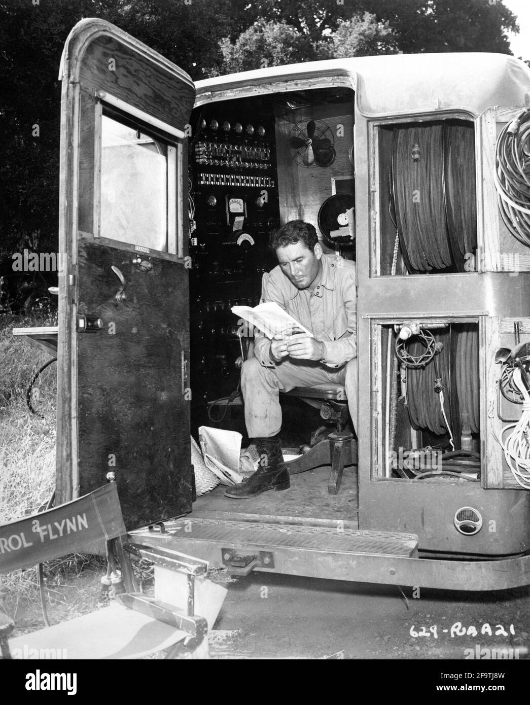 ERROL FLYNN on set location candid relaxing in sound car during filming ...