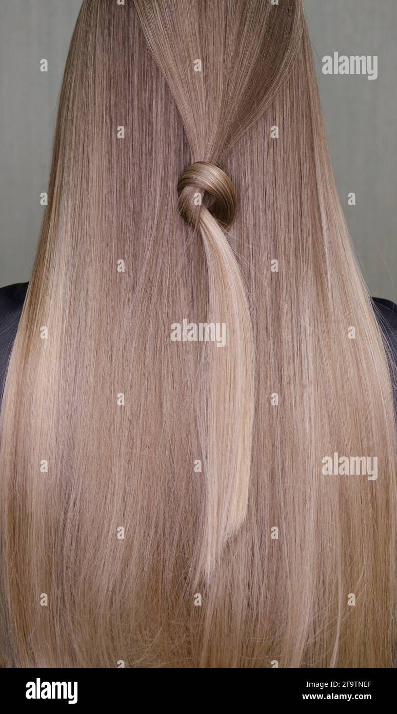 The model's beautiful hair is evenly styled and one strand is tied in a ...