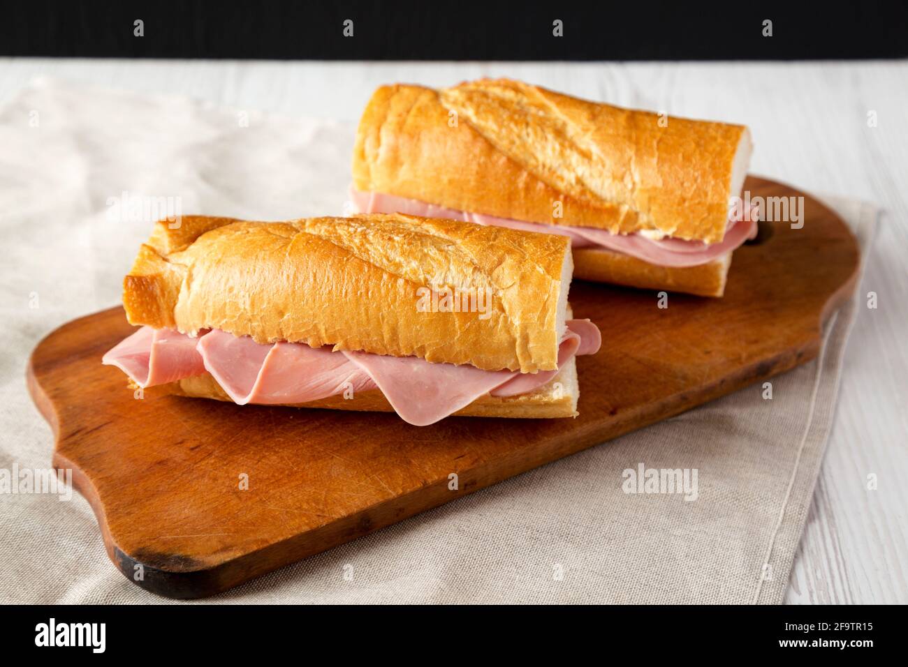 Homemade Parisian Jambon-Beurre Sandwich on a rustic wooden board, side ...