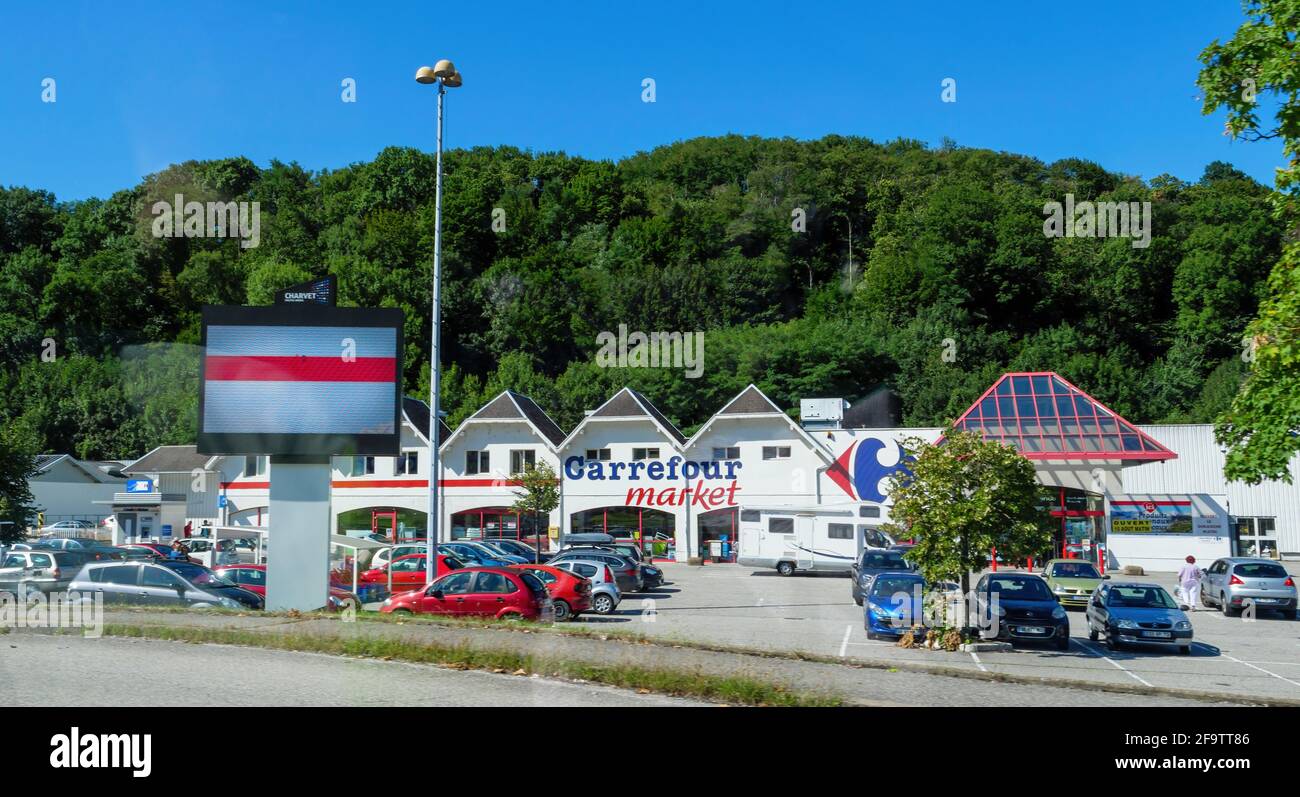 Large Carrefour supermarket mall with forest in background parked cars ...
