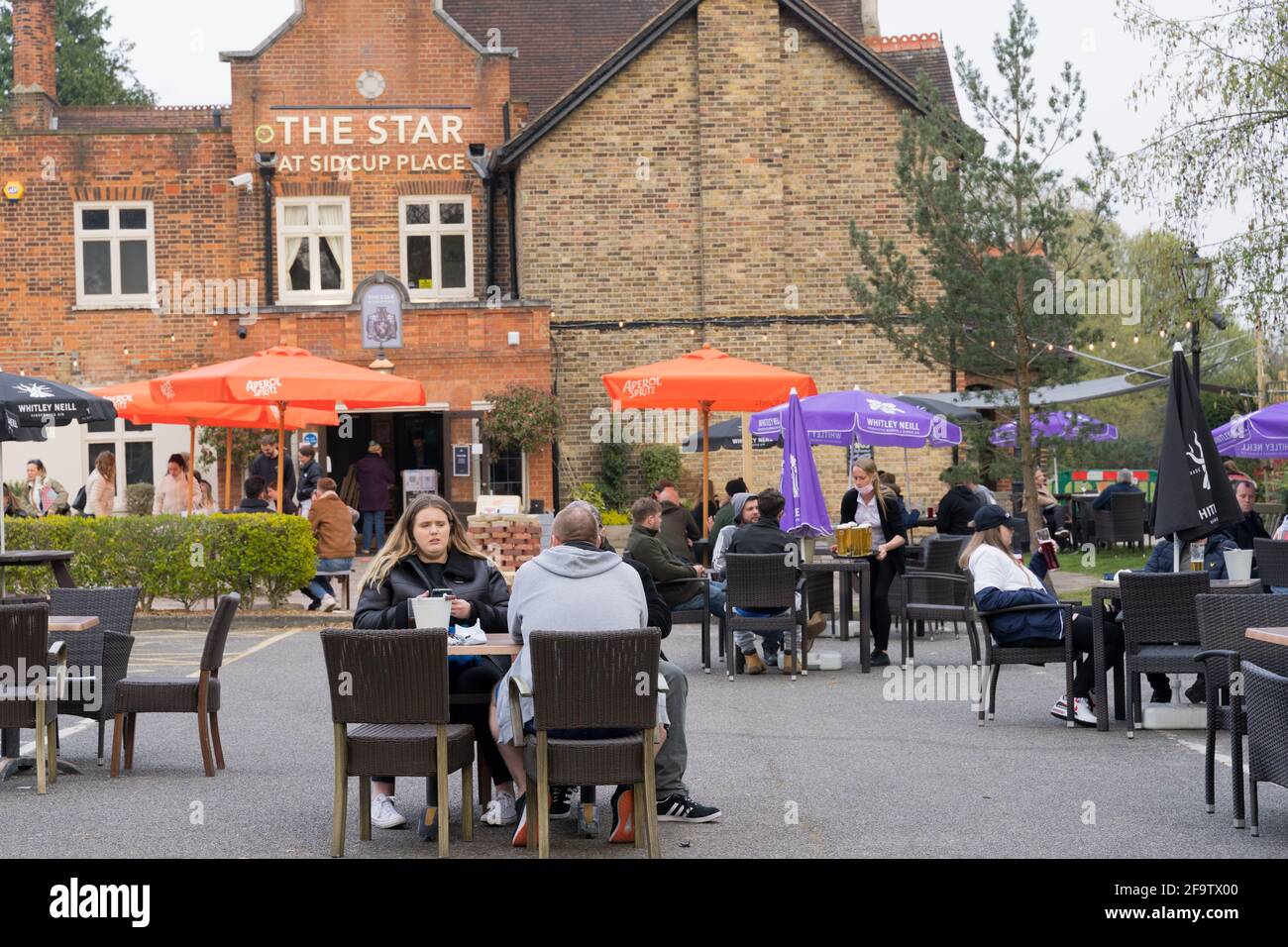 family and friends enjoy a their meal and drinks in the garden at the ...