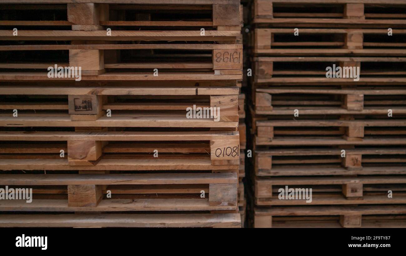Wooden pallets for industrial and transport stacked in a large column ...