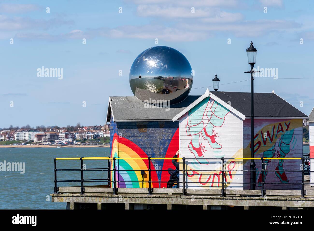 Brightly coloured huts on the end of Southend Pier, with a mirror ball ...