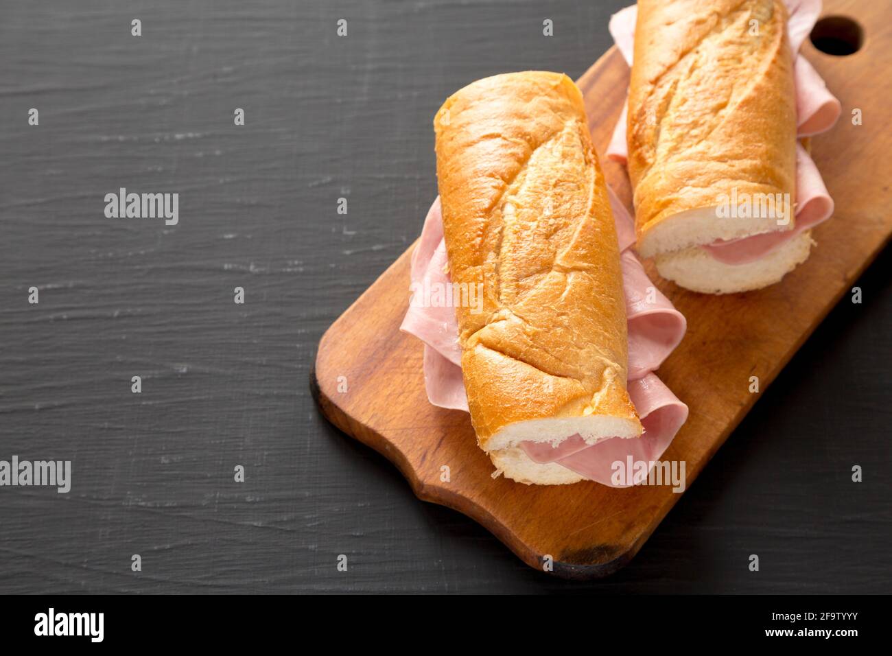 Homemade Parisian Jambon-Beurre Sandwich on a rustic wooden board on a ...