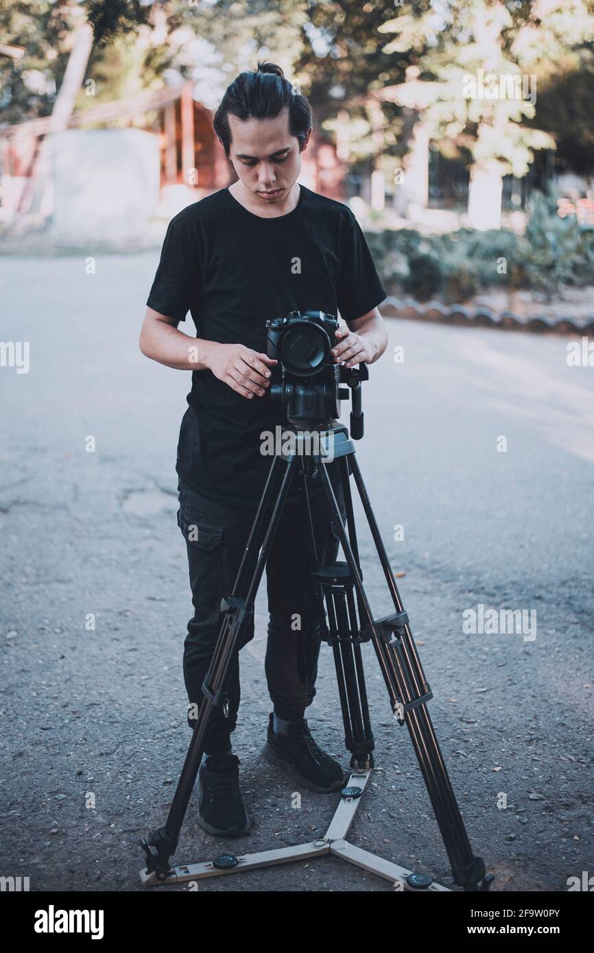 Stylish young operator in black works outdoor with a camera Stock Photo ...