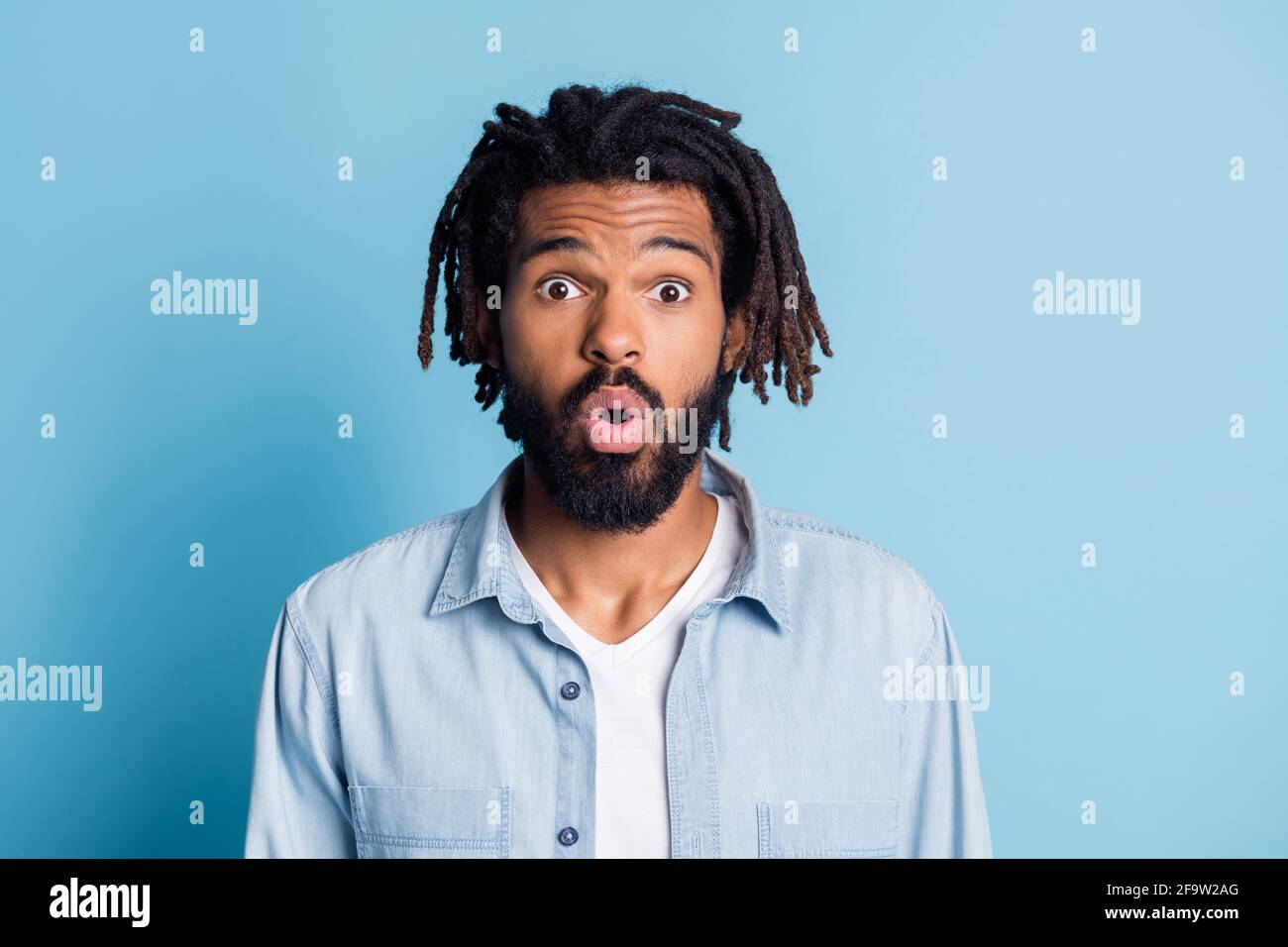 Portrait of nice worried amazed guy wearing jeans shirt sudden news ...