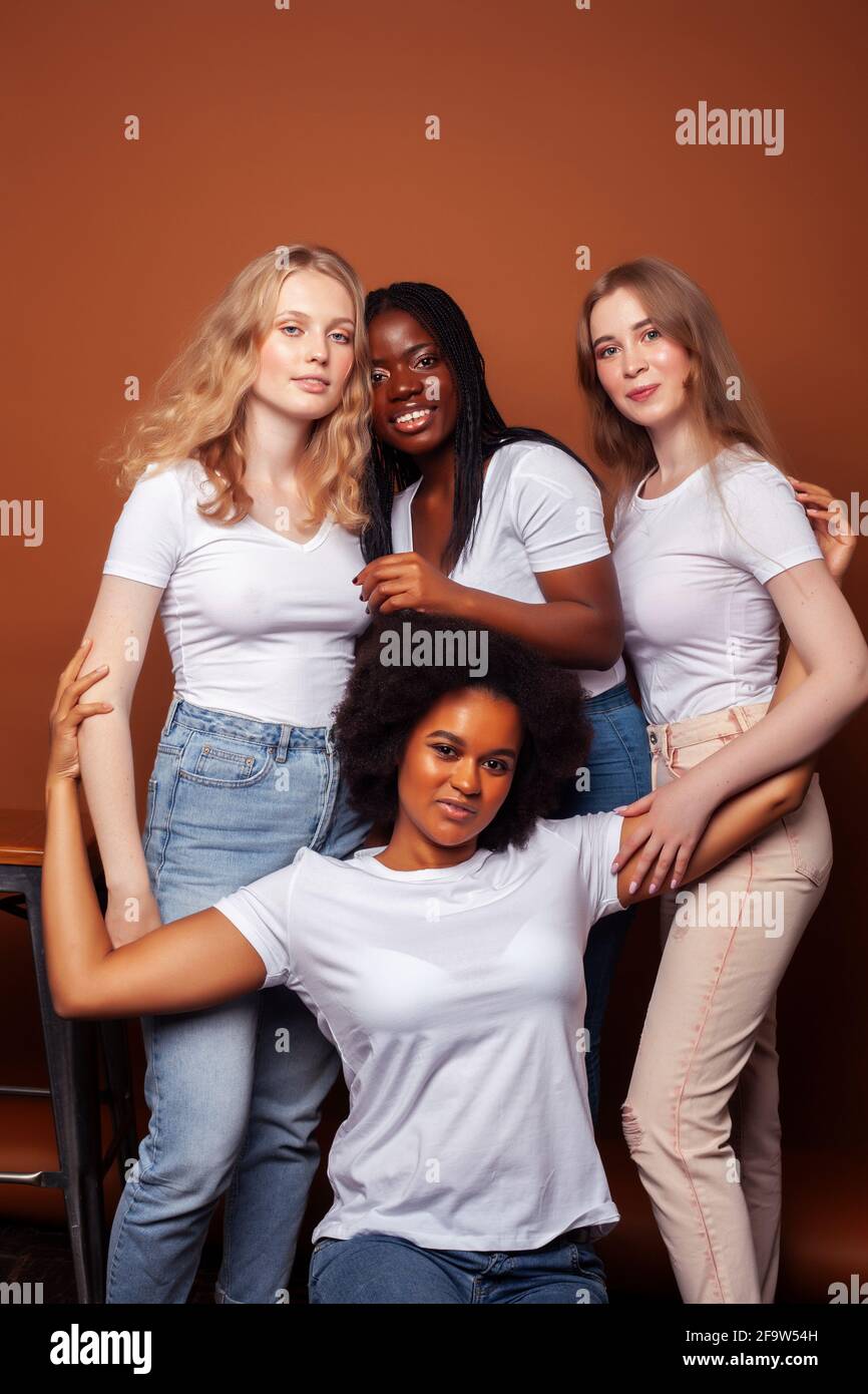 young pretty caucasian, afro, scandinavian woman posing cheerful together on brown background ...