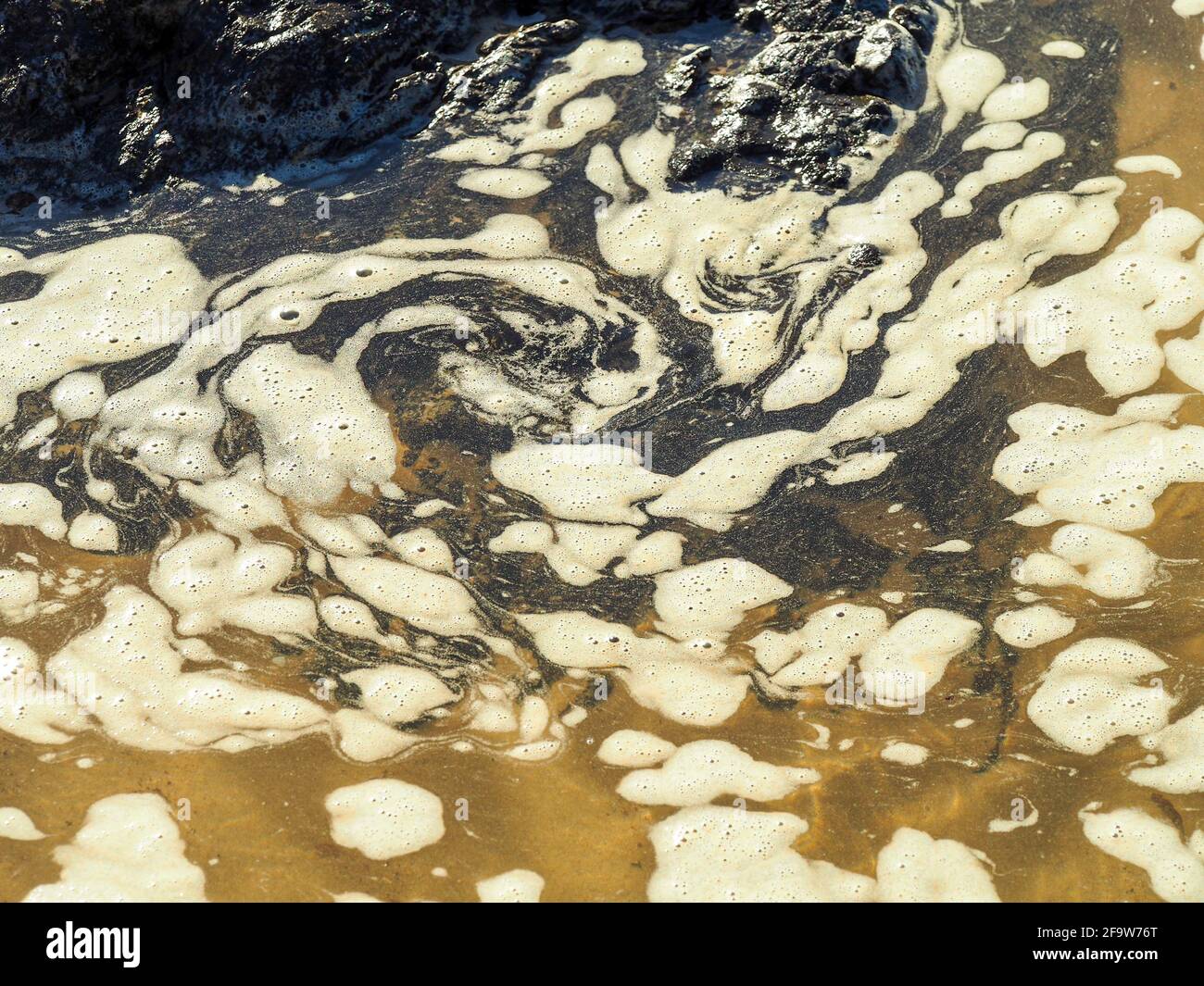 Swirling frothy sea water in the rock pools spiralling around Stock ...