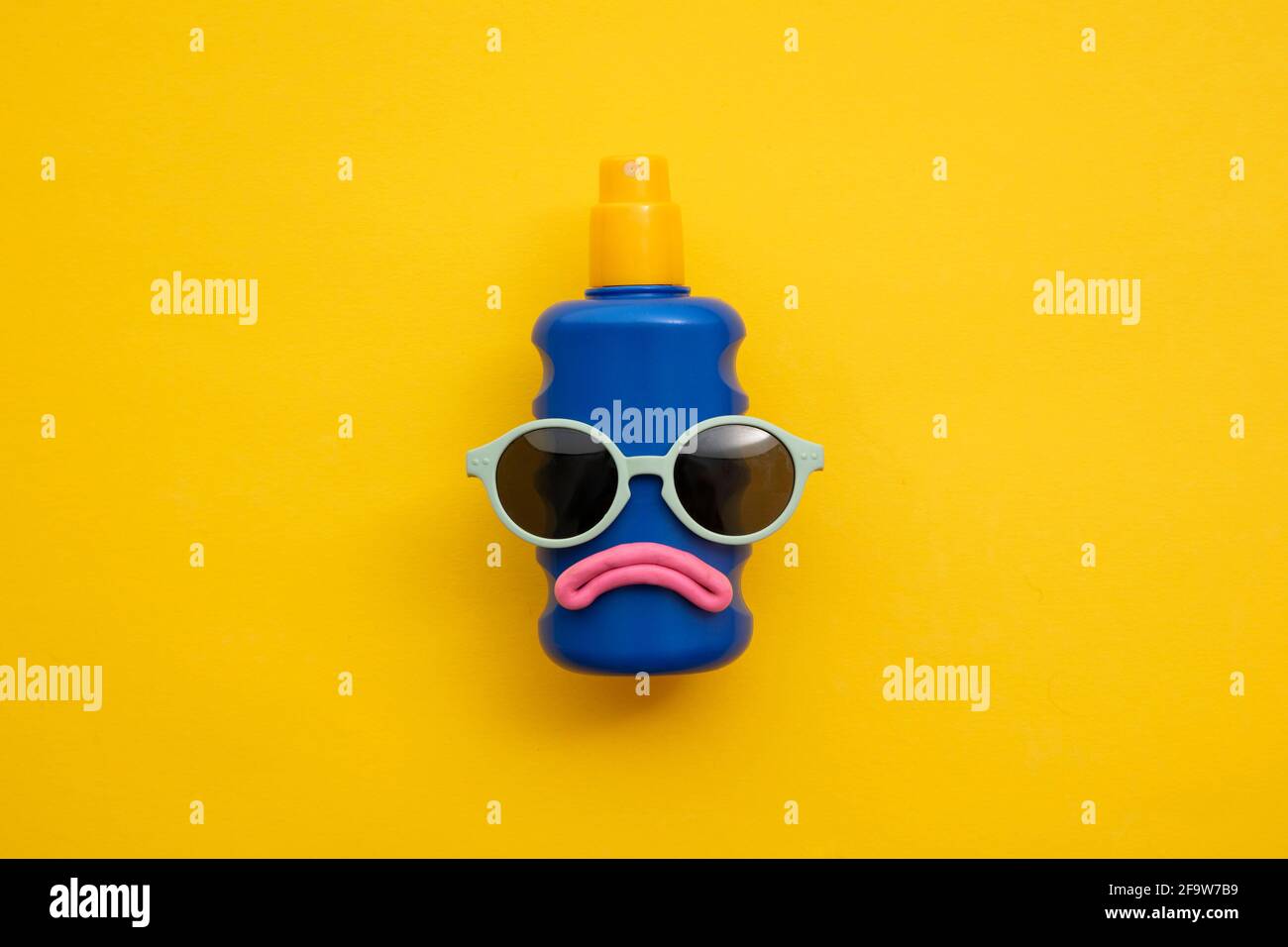 Suncream lotion bottle with a sad face and sunglasses. Summer sunburn ...