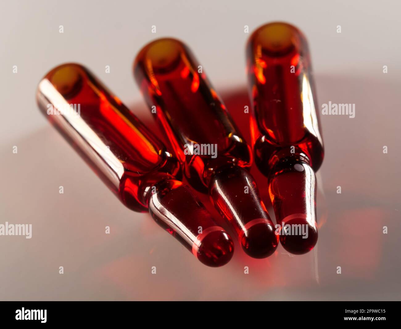 Selective focus shot of three red ampoules isolated on a white ...