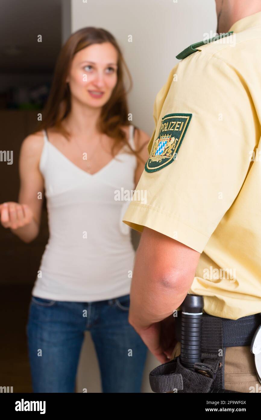 Police officer at front door of home interrogating a woman or witness ...