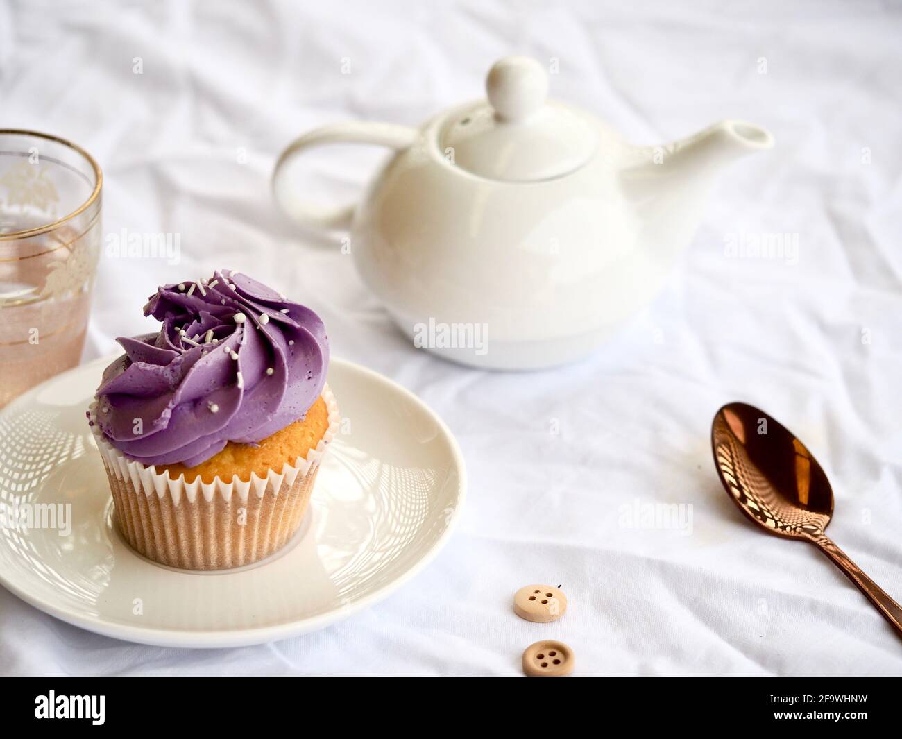 Cupcake and white teapot on a pretty white textured background Stock ...