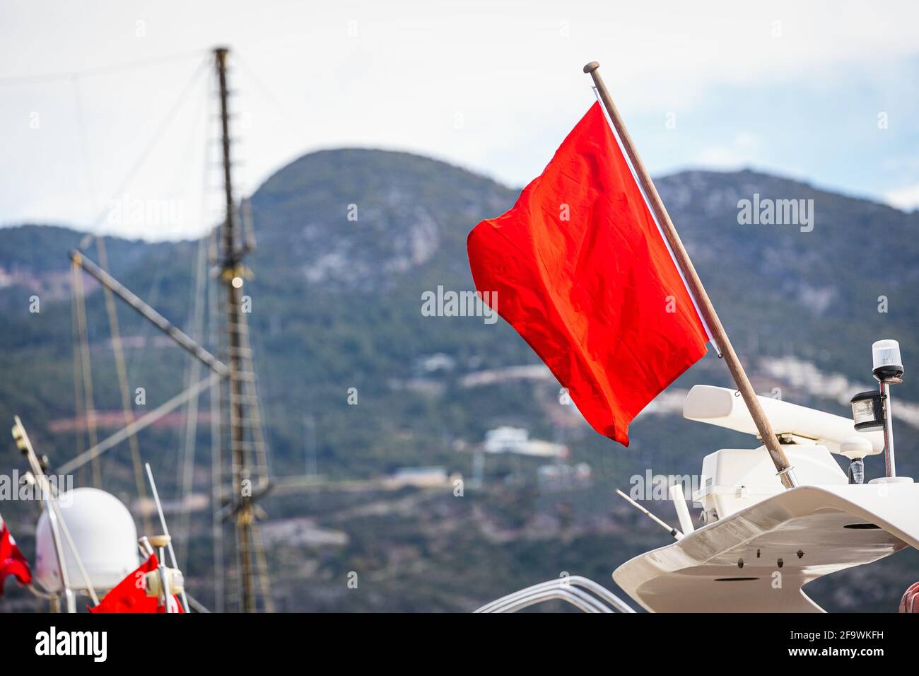 Red flag waving attached to a white yacht against the backdrop of the ...