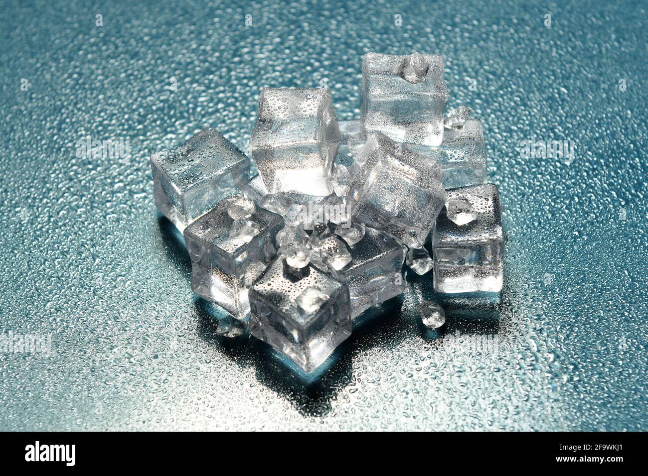 ice stone on reflective surface of background with drops, idea of a ...