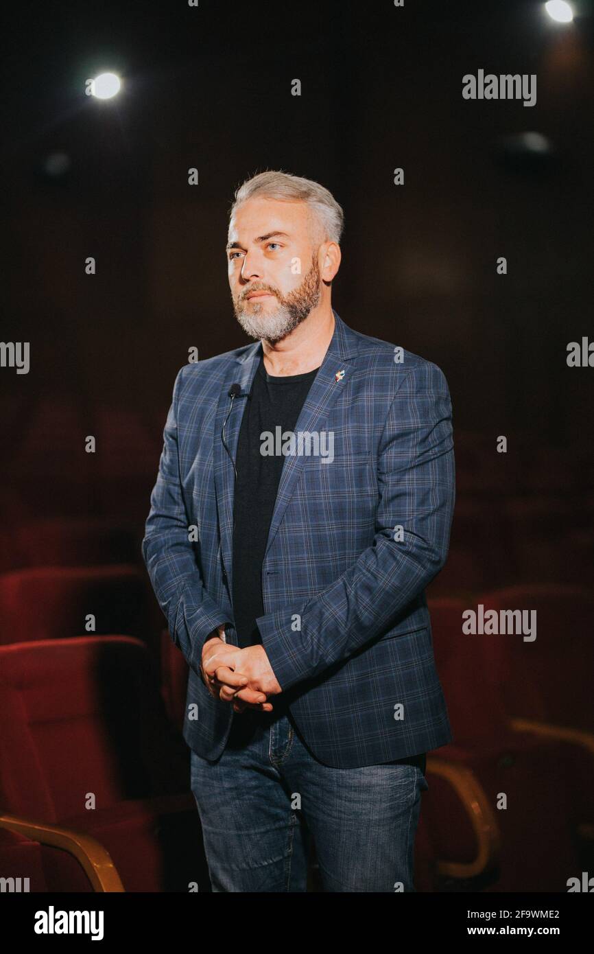 Elegant male theatre and movie director giving an interview in ...