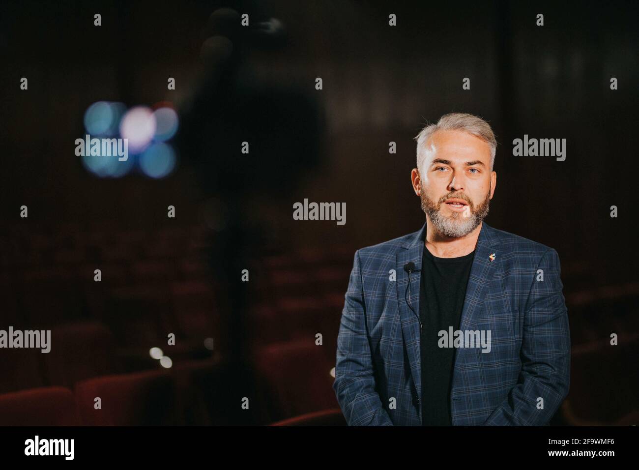 Elegant male theatre and movie director giving an interview in ...