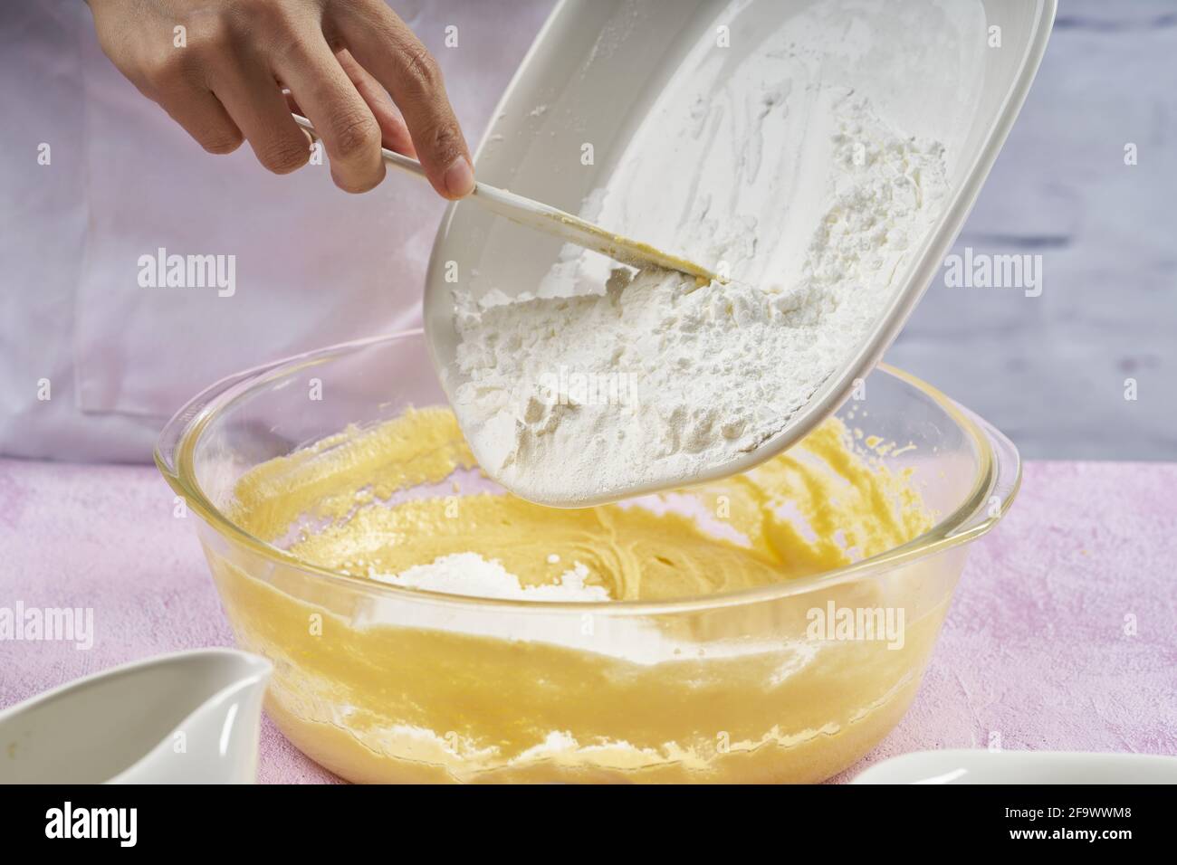 Adding flour to a mixing bowl - concept of baking Stock Photo - Alamy