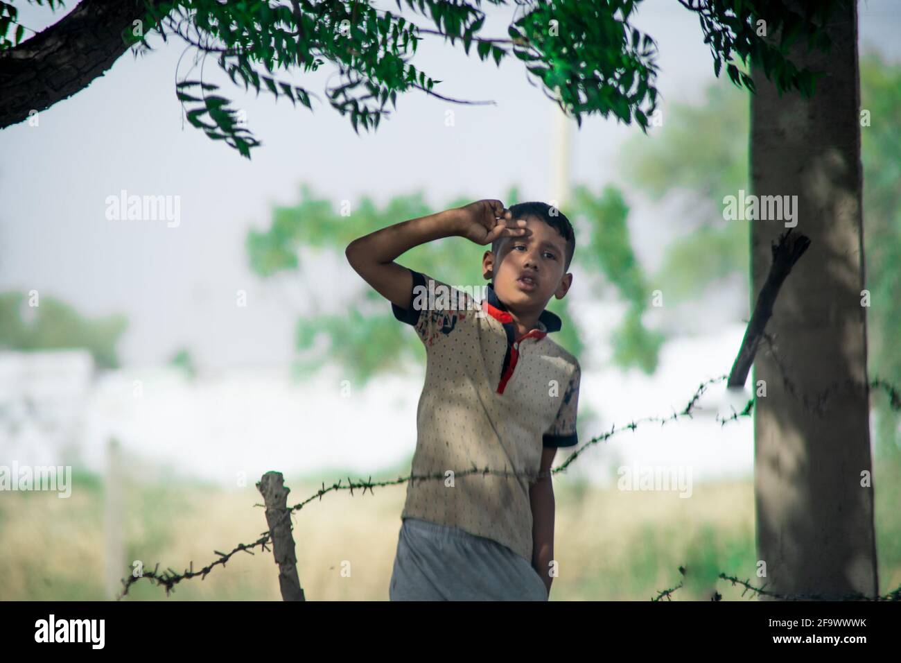 Young poor village boy looking at the camera saluting surprised ...