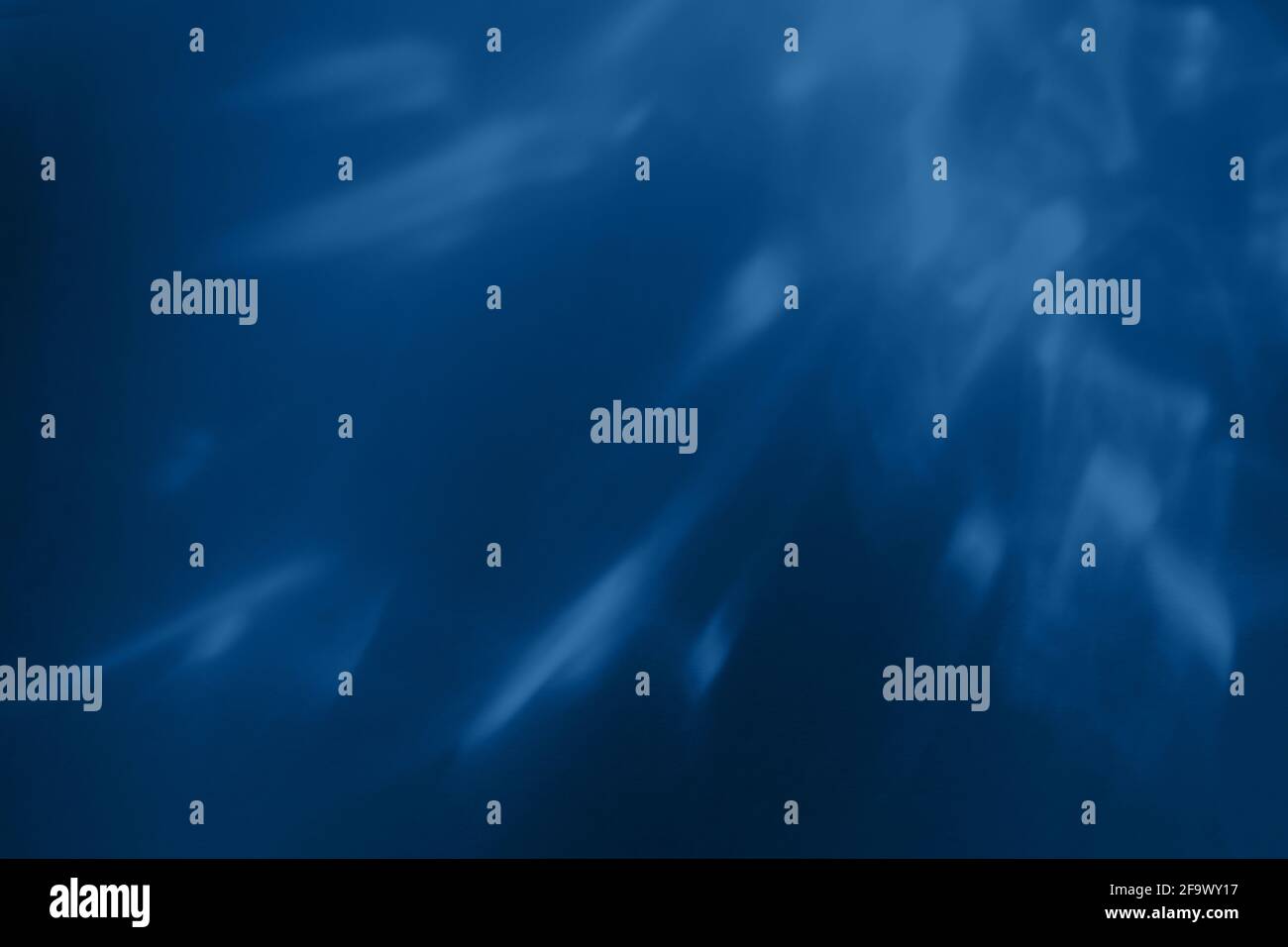 blue colored abstract background with light and shadows caustic effect ...