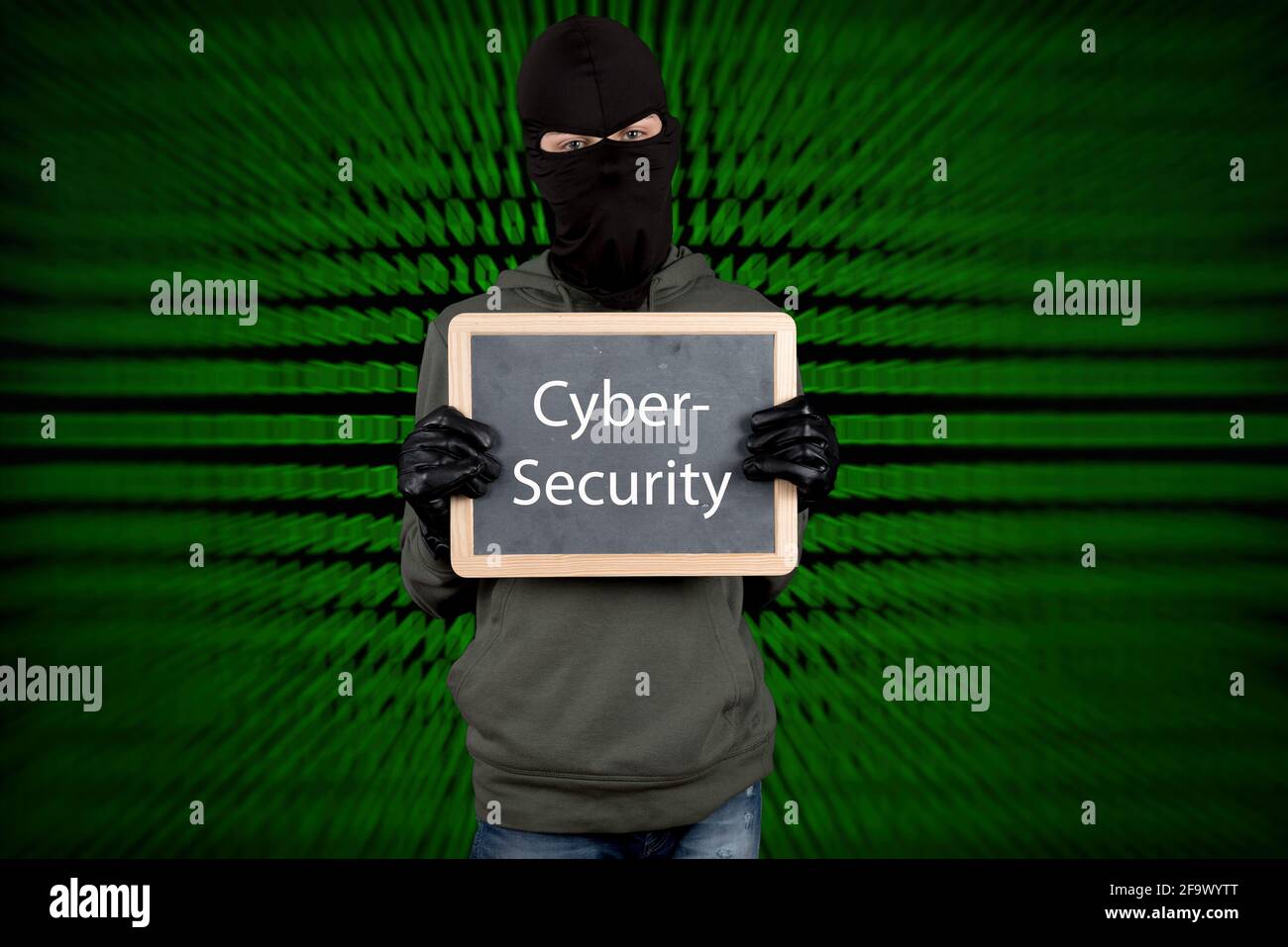 Hacker holding a blackboard with CYBER-SECURITY written on it, in front ...