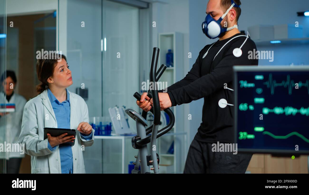 Performant sportsman measuring heart rate with performant ekg equipment ...