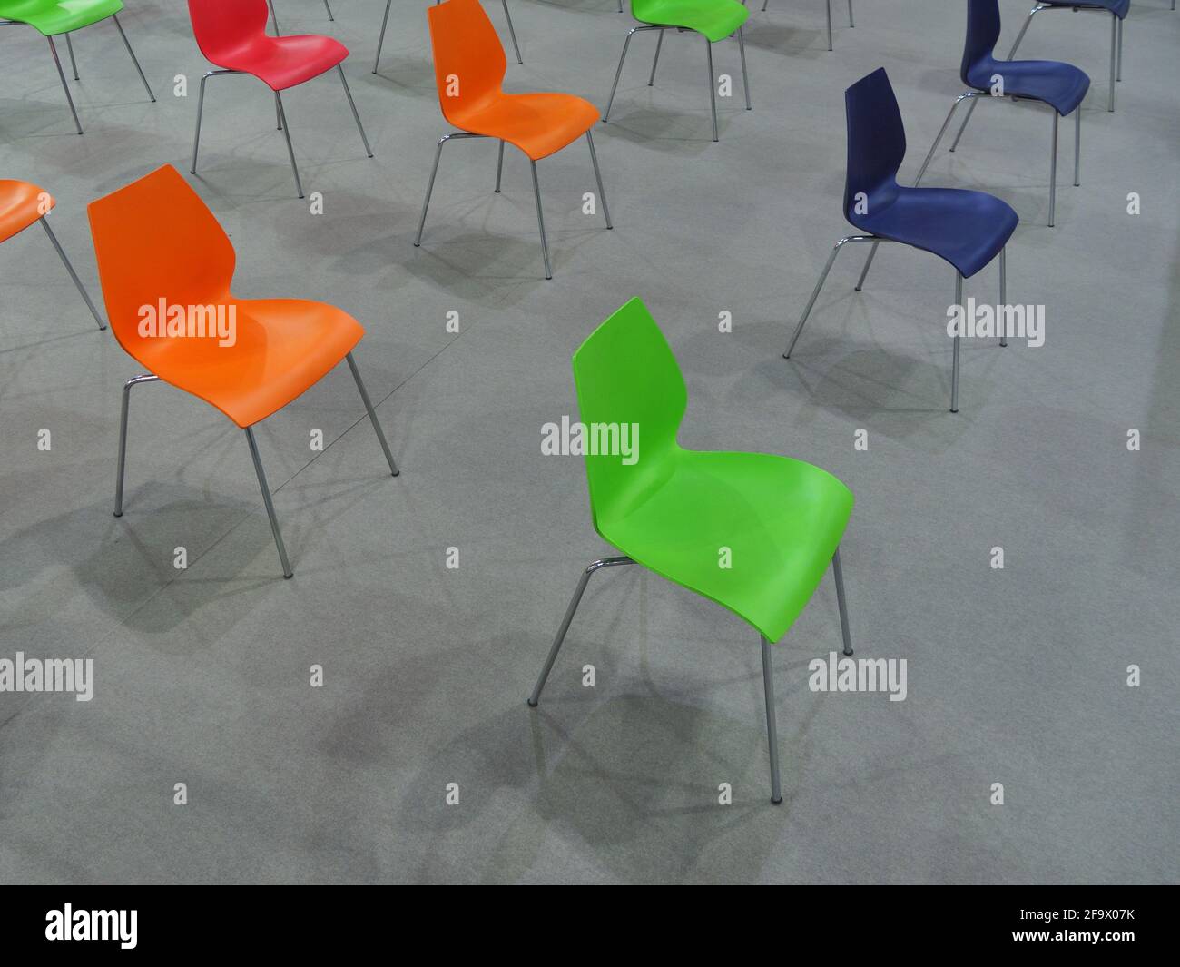 High angle shot of colorful chairs arranged with distance between them ...