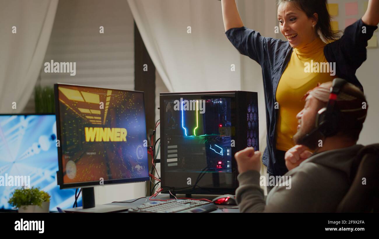 Excited couple gamer winning first person shooter online video game on ...