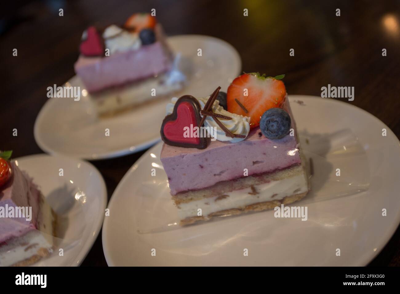 Selective focus shot of an appetizing cake with cream and berries on a ...