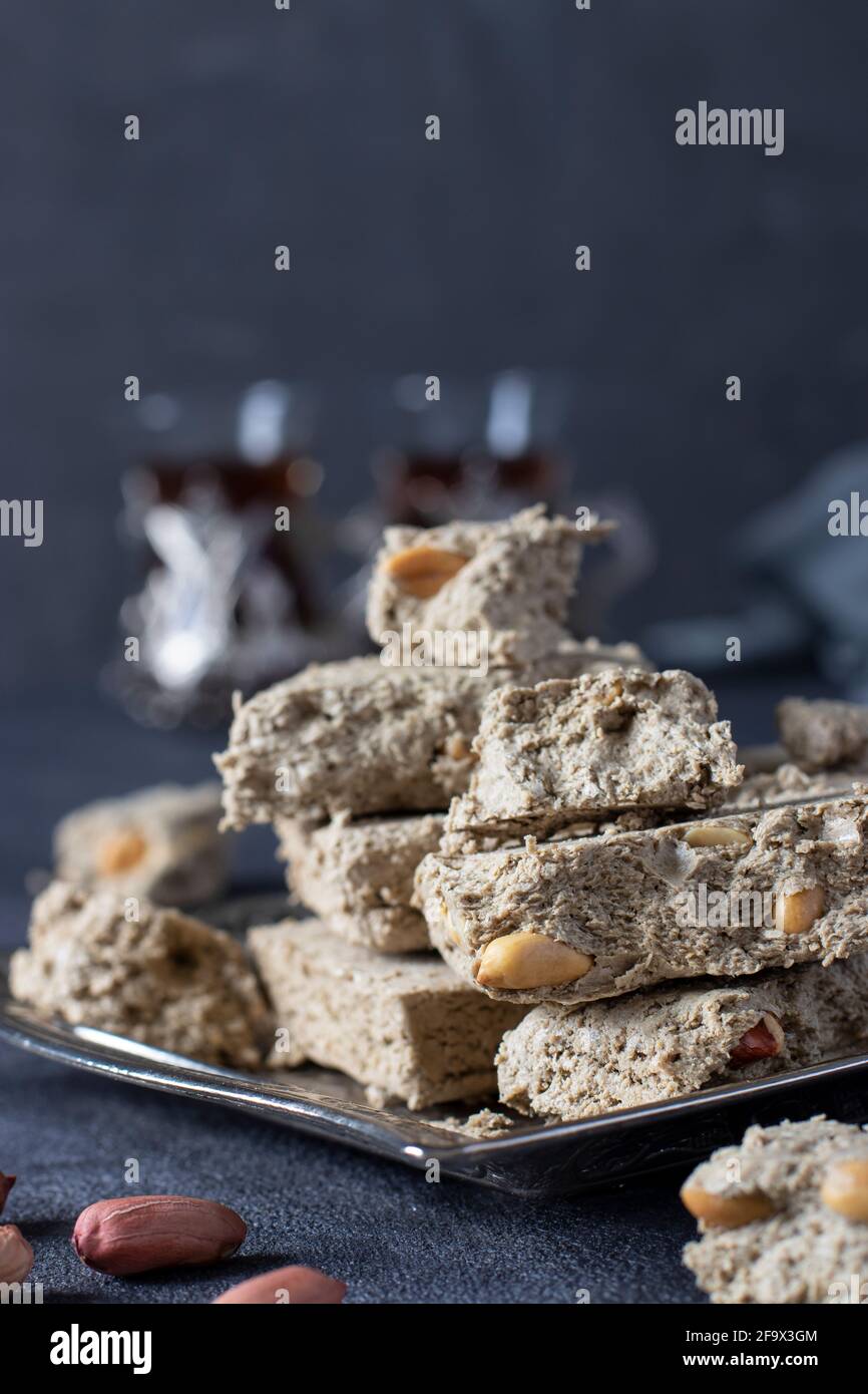 Sweet sunflower halva with peanut on metal tray on dark gray background ...