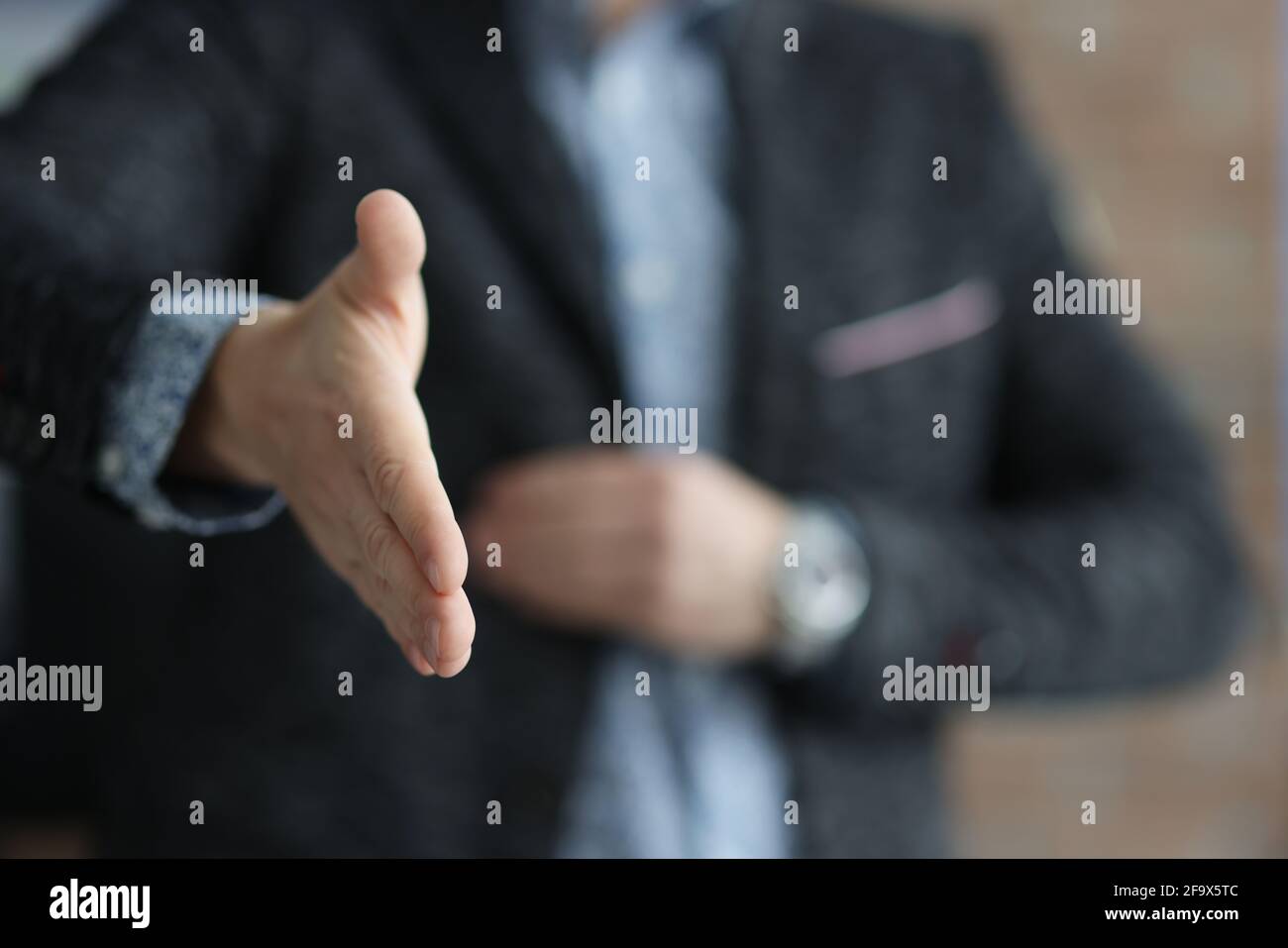 Man in black jacket stretching out his hand for handshake closeup Stock ...