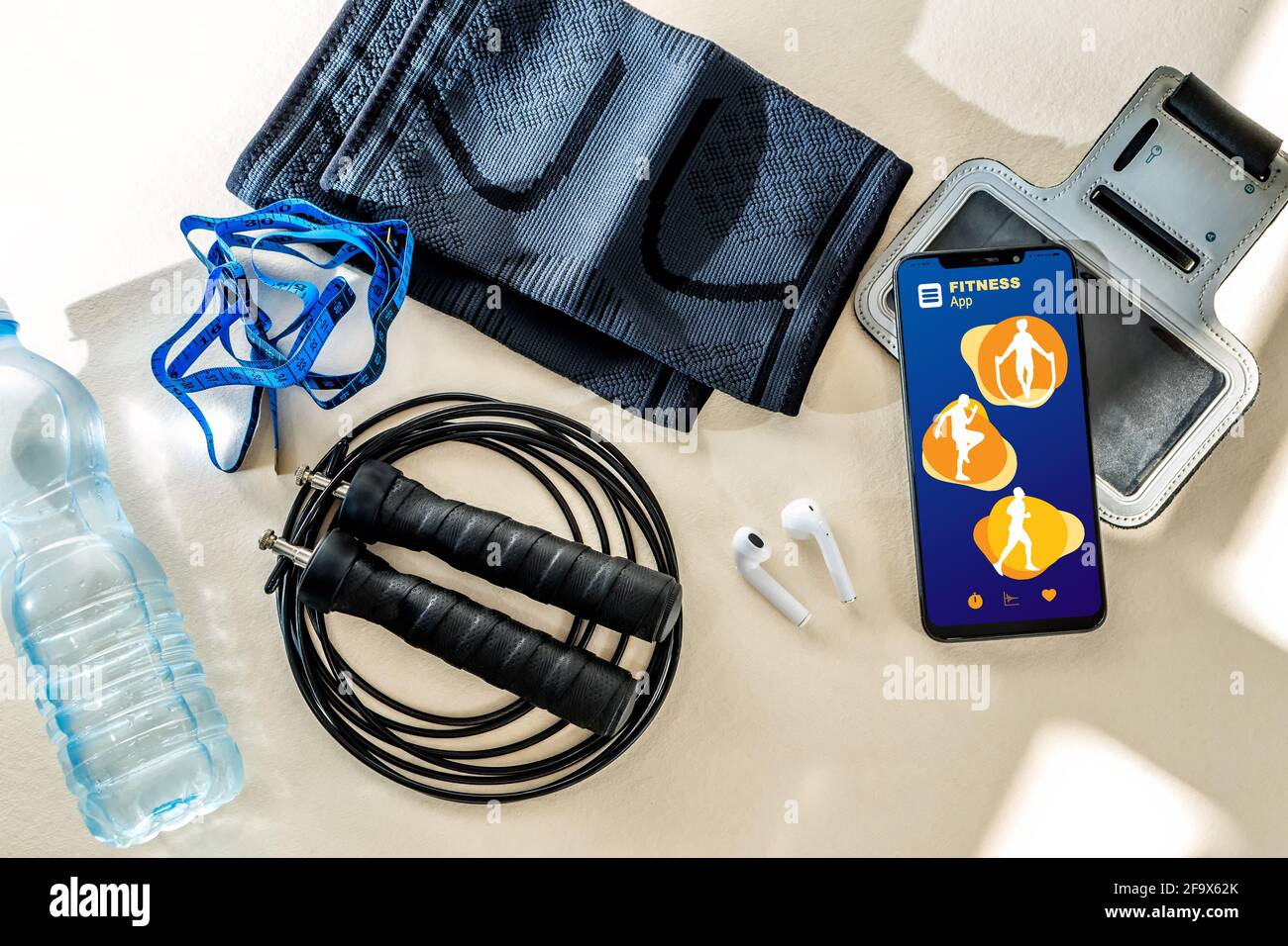 Top view of a smartphone showing a fitness app next to jump rope and ...