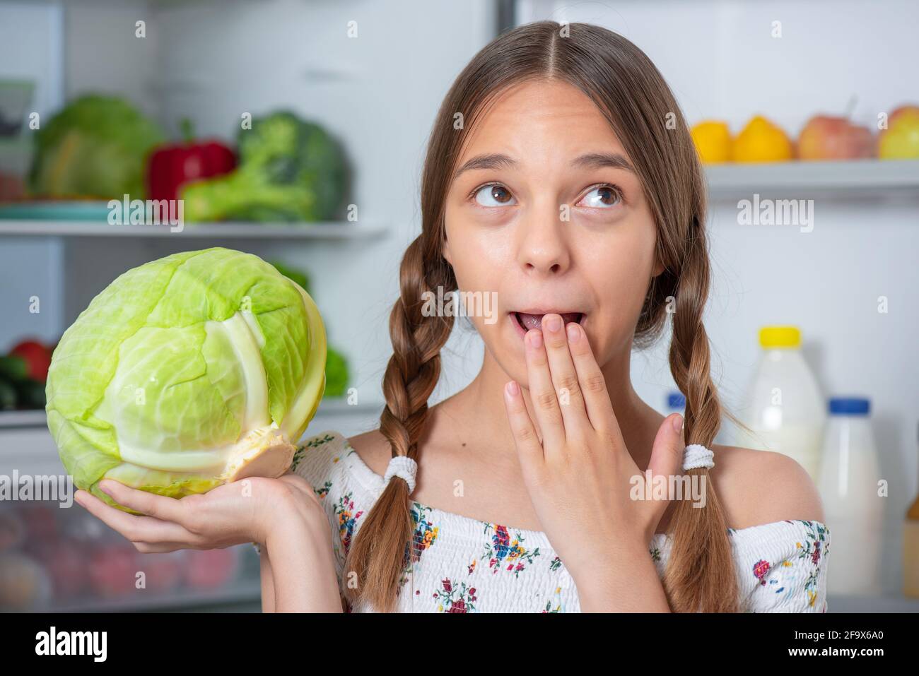 Beautiful young teen girl holding fresh green cabbage while standing ...