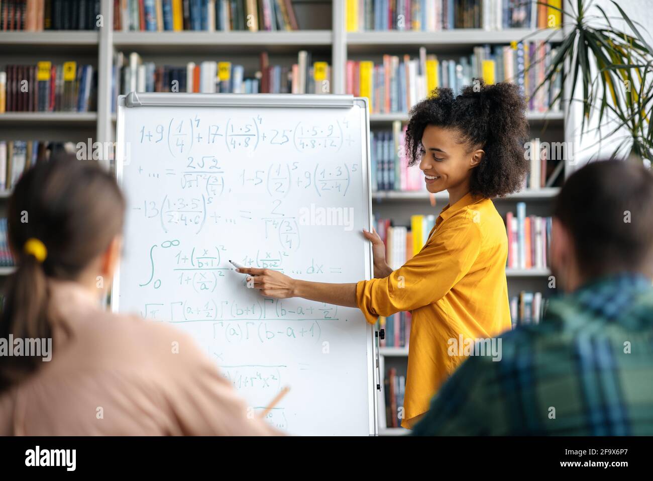 Teaching concept. Smiling african american clever female teacher stands ...