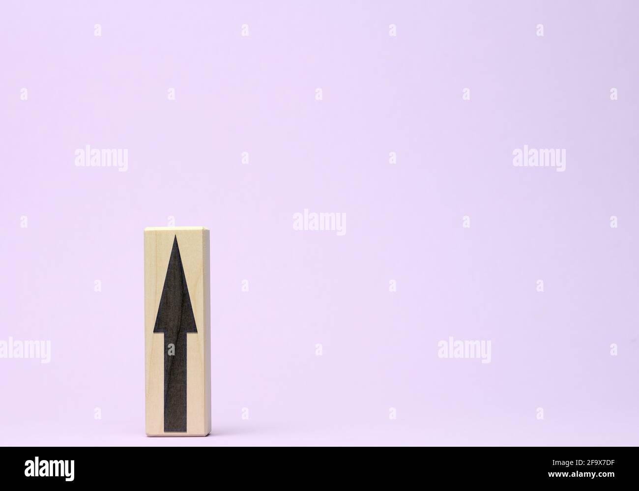 wooden block with an upward arrow on a purple background, the process ...